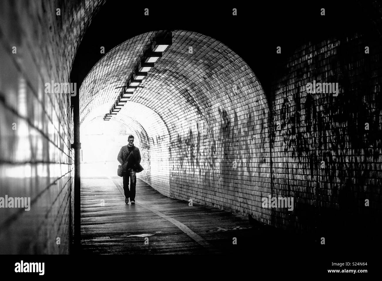 Man walking through a tunnel Stock Photo - Alamy