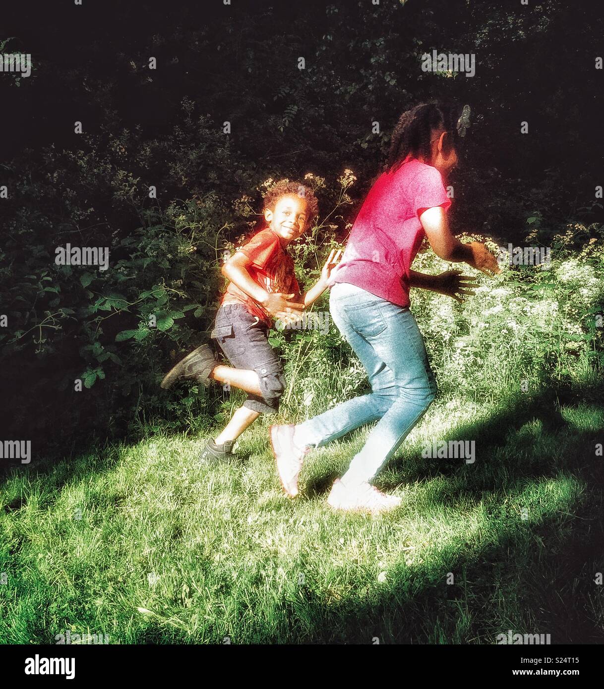 Children running through the grass Stock Photo - Alamy