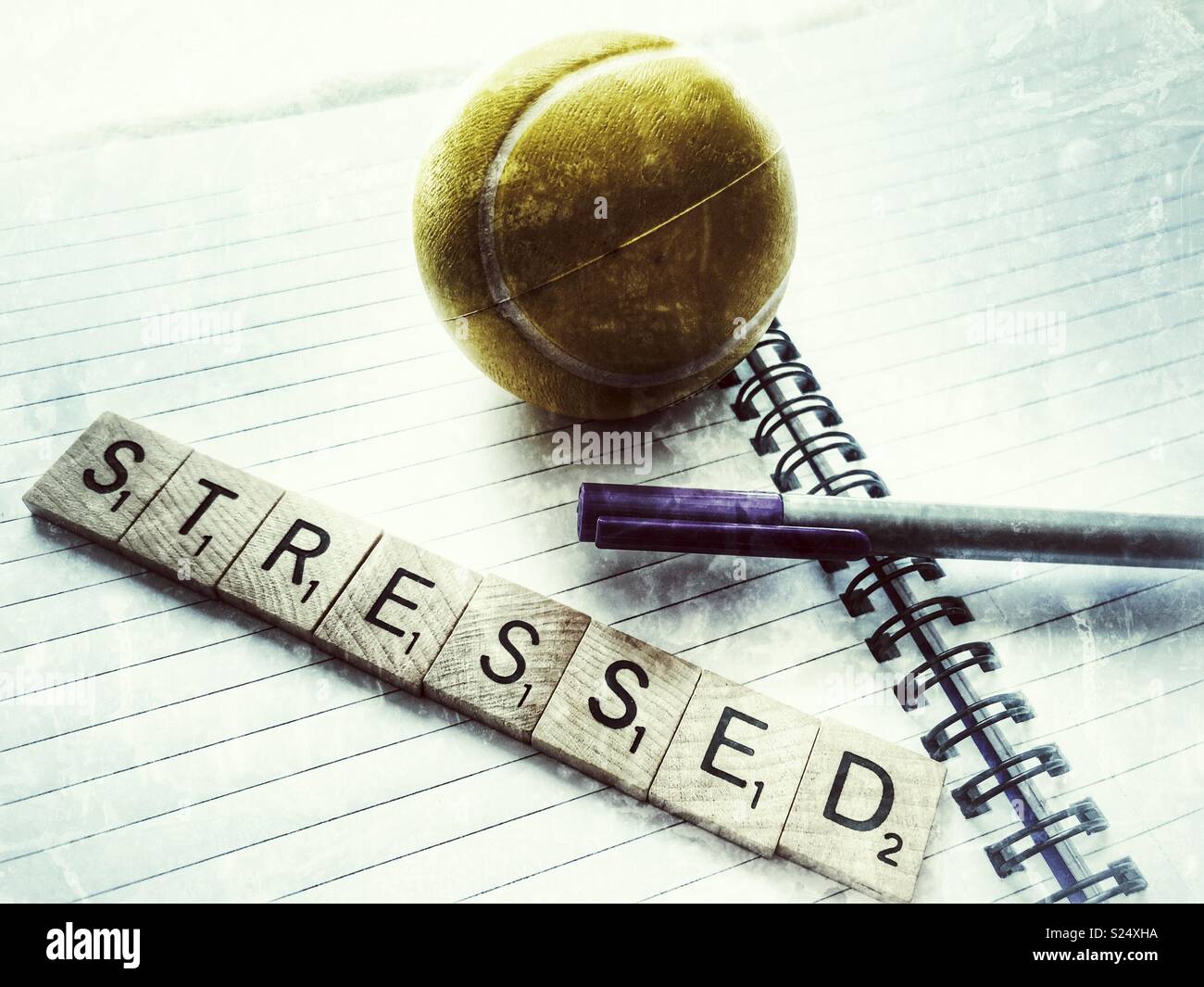stress ball, pen, and the word Stressed in wooden letters on an open ...