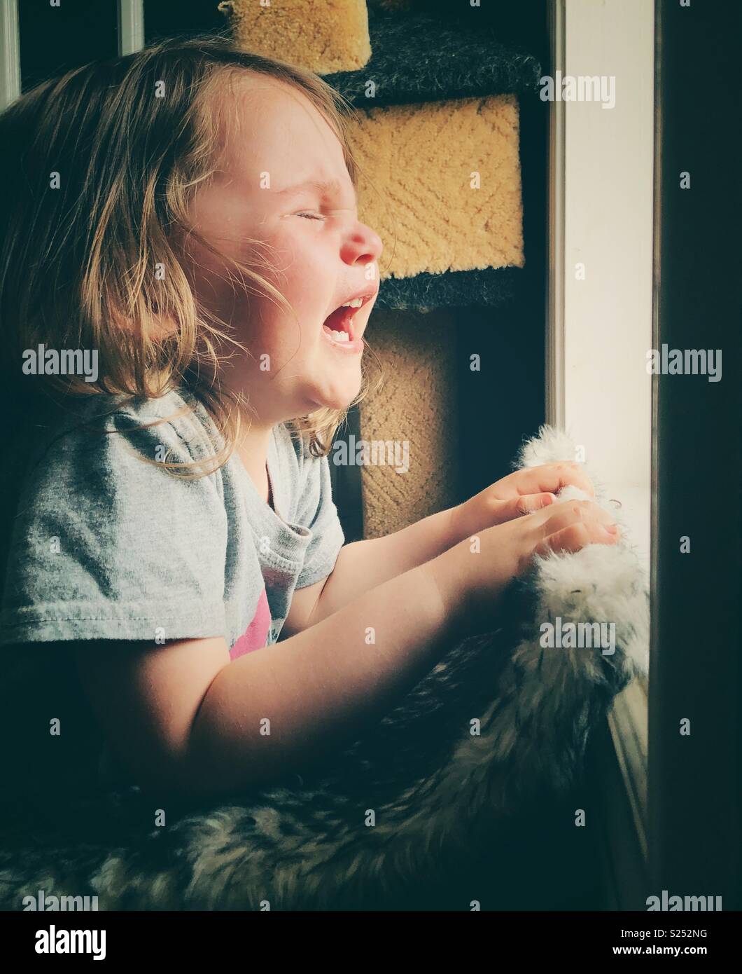 Toddler girl crying at a window during a temper tantrum Stock Photo - Alamy