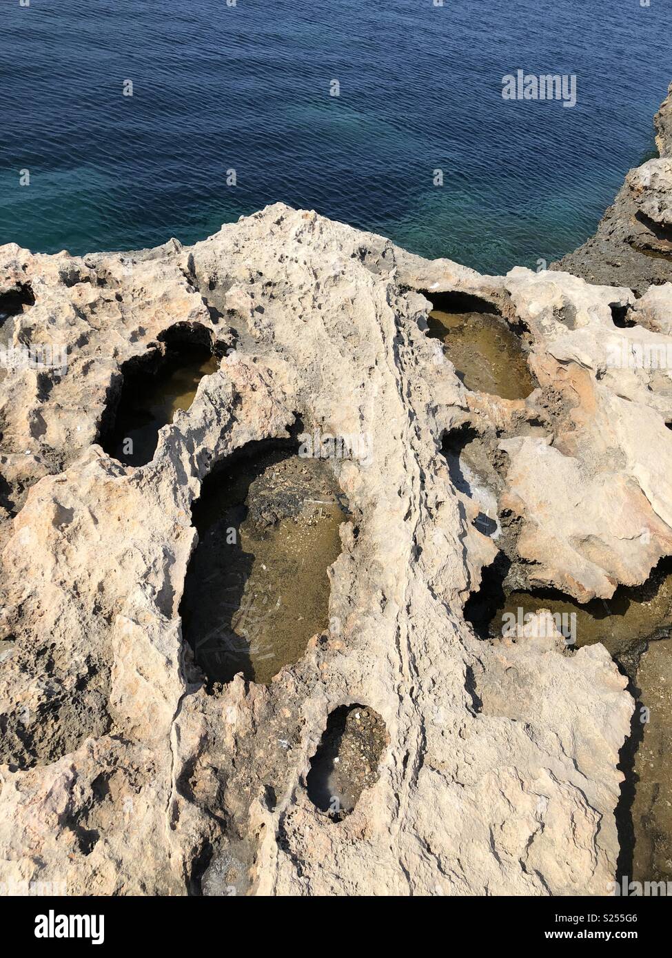 Rock with holes and sea on Ibiza in Spain Stock Photo - Alamy