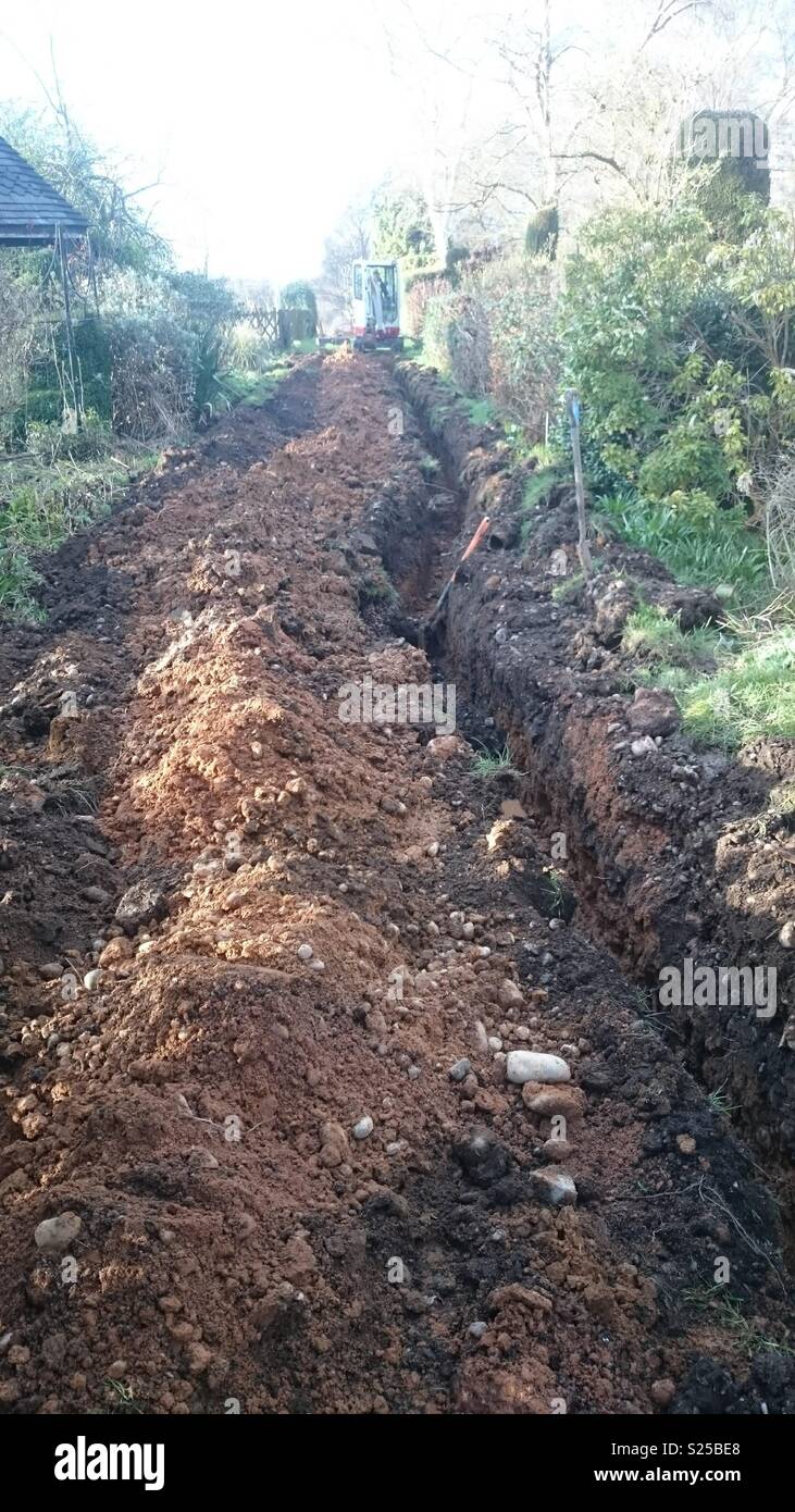 Trench for ground loop being dug. Ground Source Heat Pump installation ...