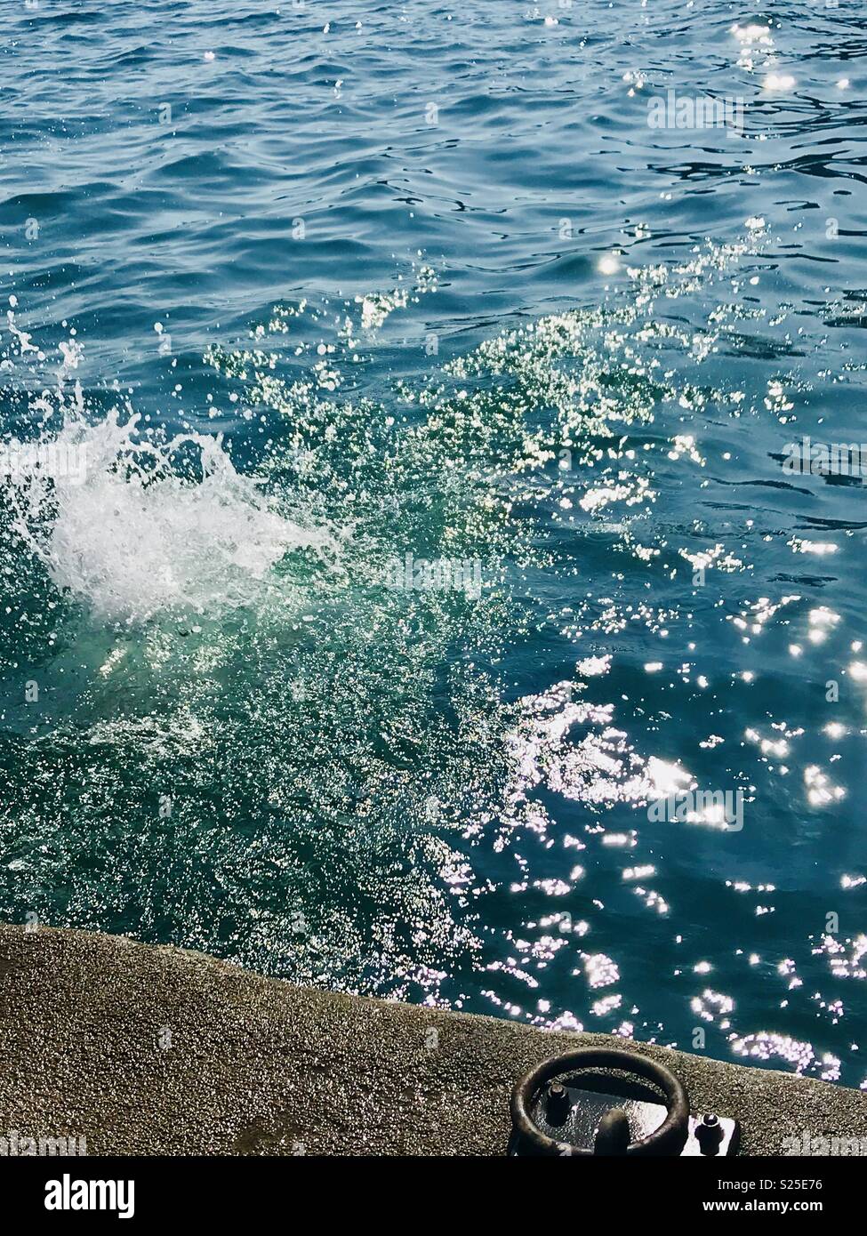 Splashing water as a body dives in Stock Photo - Alamy