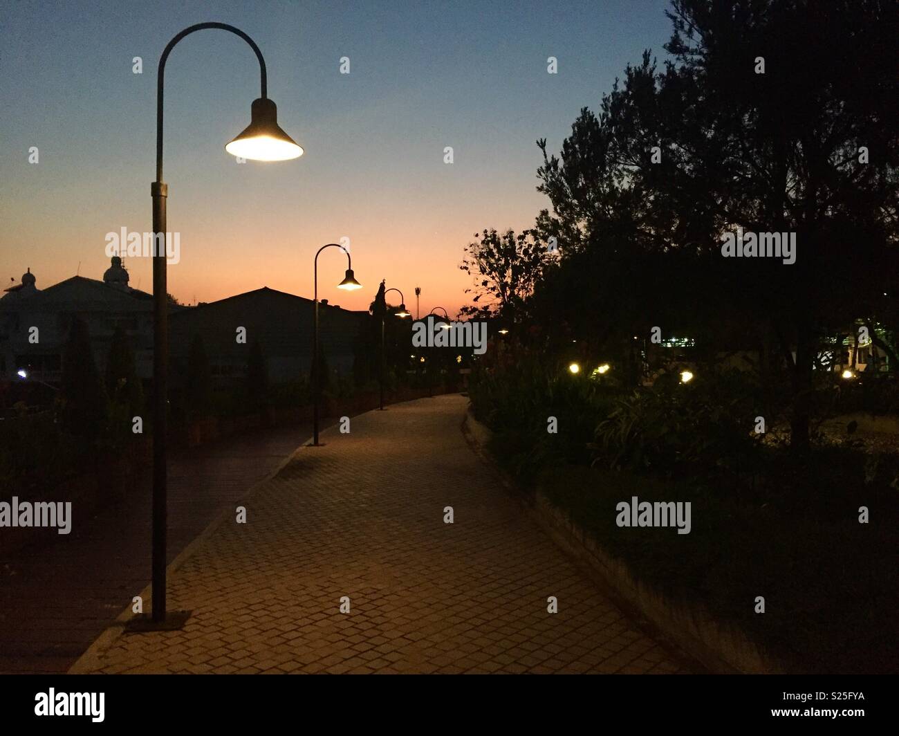 Walkway and row of lamp post lighting Stock Photo - Alamy