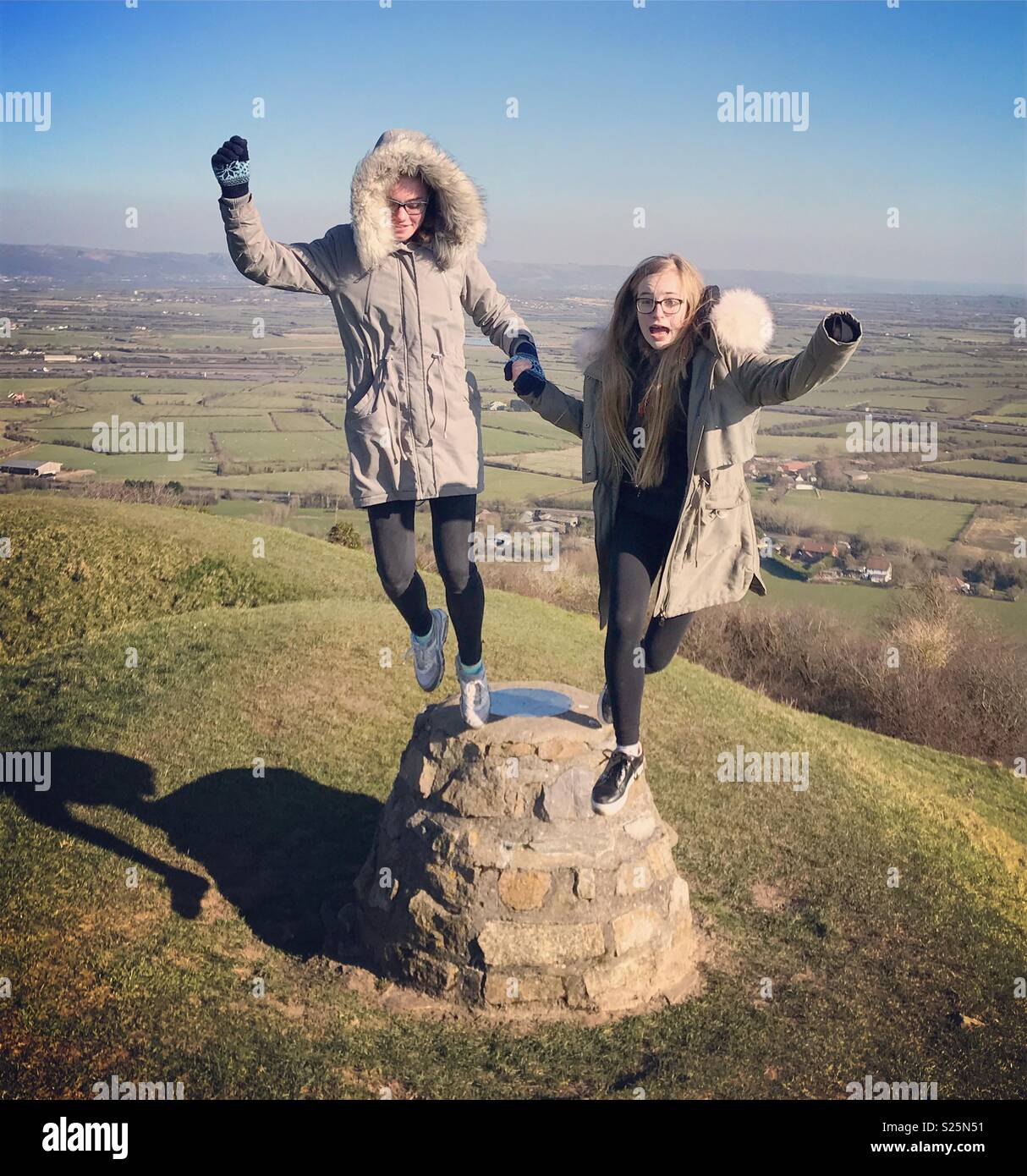 Girls holding hands jumping hi-res stock photography and images - Alamy