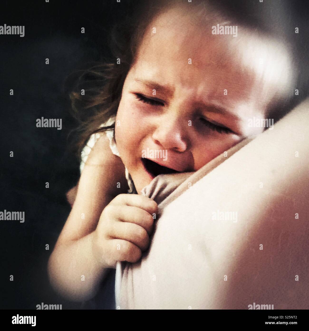 Toddler girl grabbing parent’s shirt and crying during a temper tantrum ...