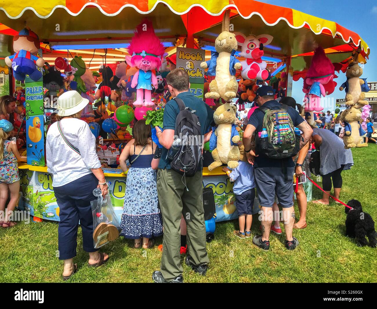Parents and children surrounding Hook a Duck, a side stall game at the ...