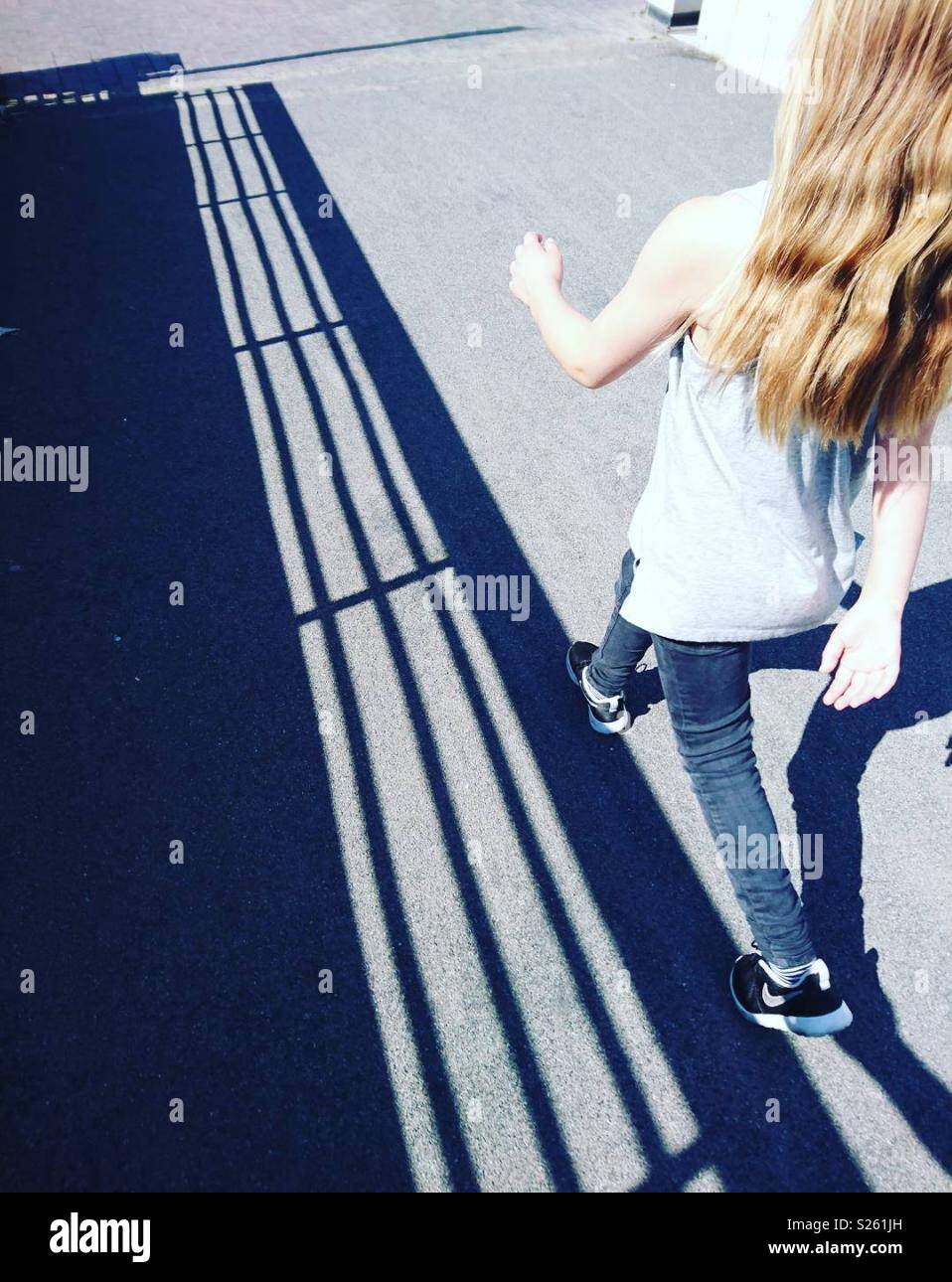 Walking with shadows Stock Photo - Alamy