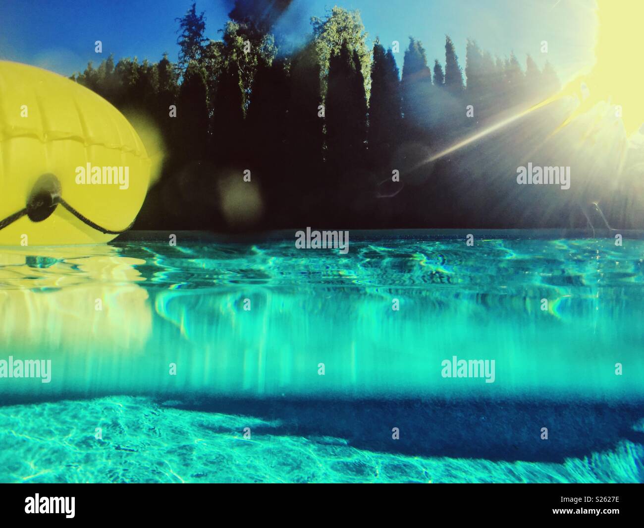 Yellow inflatable floaty in an outdoor swimming pool on a sunny day ...