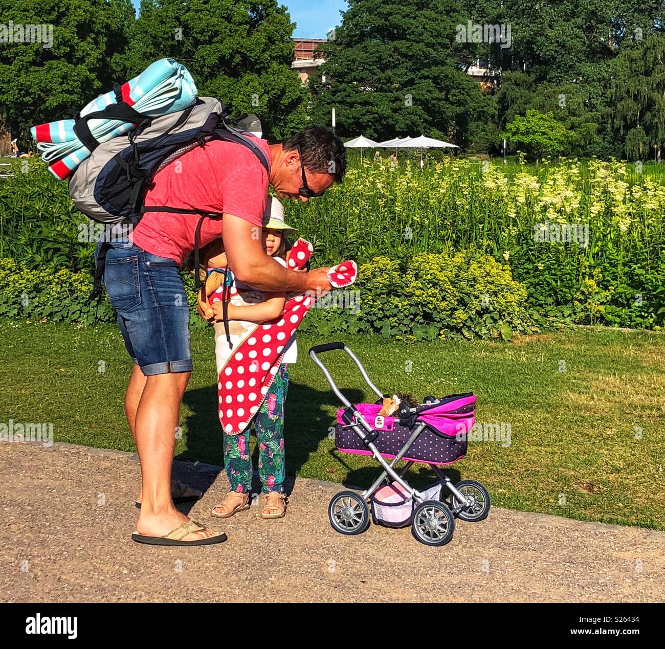 Father helps his daughter with her baby doll Stock Photo - Alamy
