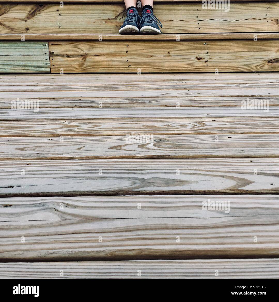 Person sitting on wooden steps Stock Photo - Alamy