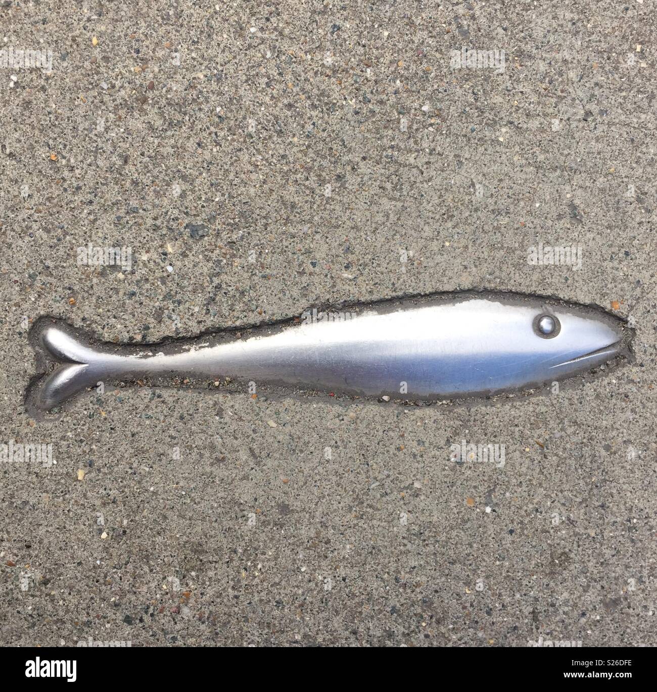 Metal fish sunk into stone Stock Photo - Alamy
