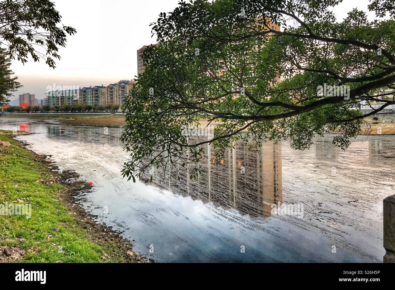 Buildings reflected in a river Stock Photo - Alamy
