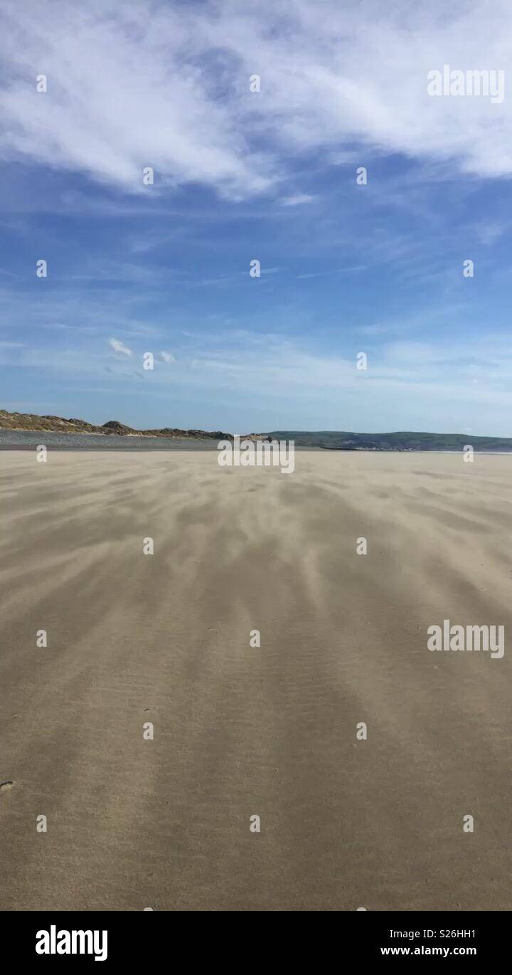 Wind moving sand on the beach in a sunny day Stock Photo - Alamy