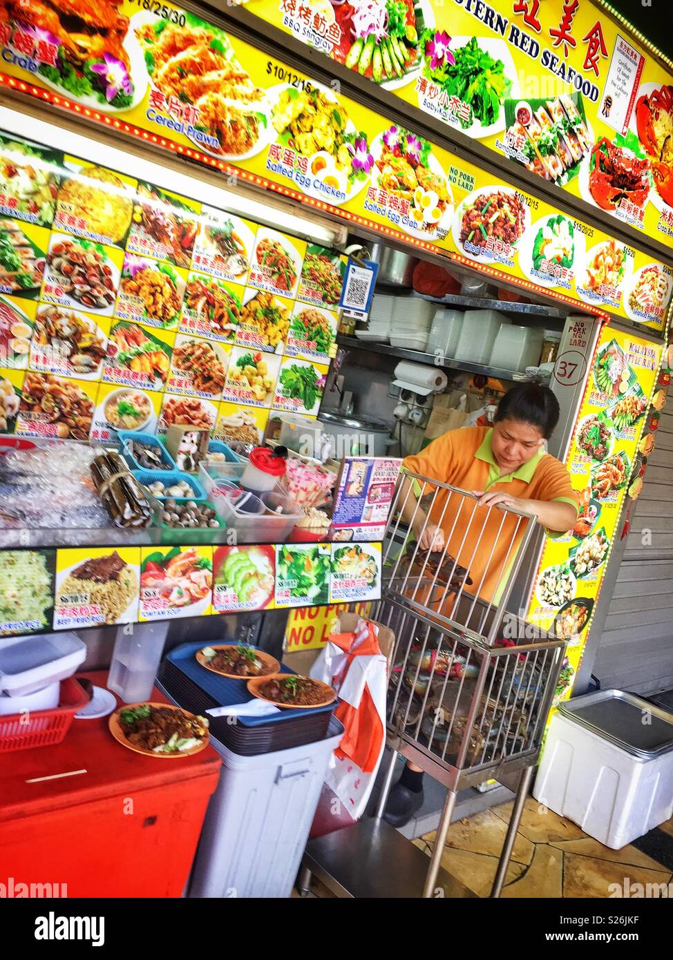 A woman selects a live mud crab for cooking at East Coast Lagoon Food ...