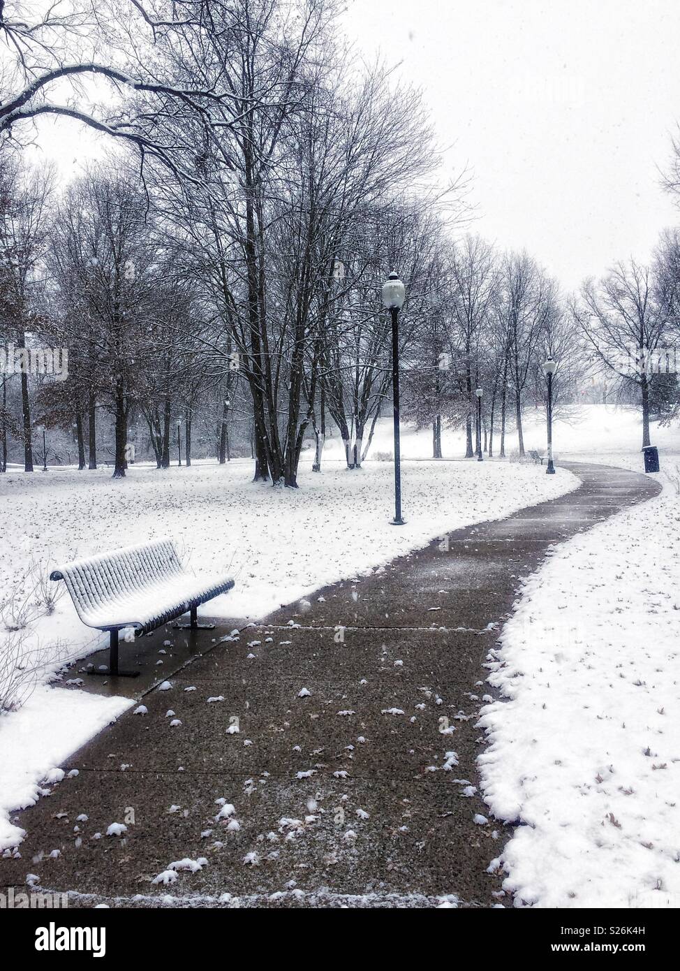Snowy sidewalk with bench and lamp post Stock Photo - Alamy