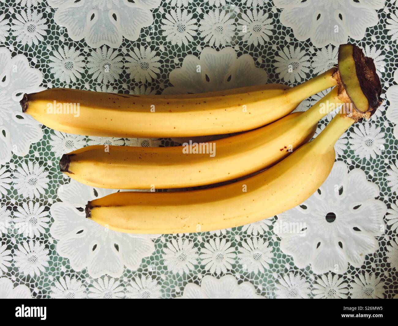 Three bananas on a table Stock Photo - Alamy