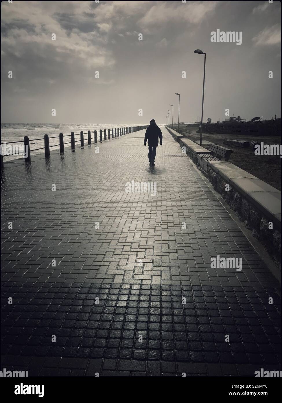 Man walking along Seapoint promenade Stock Photo - Alamy