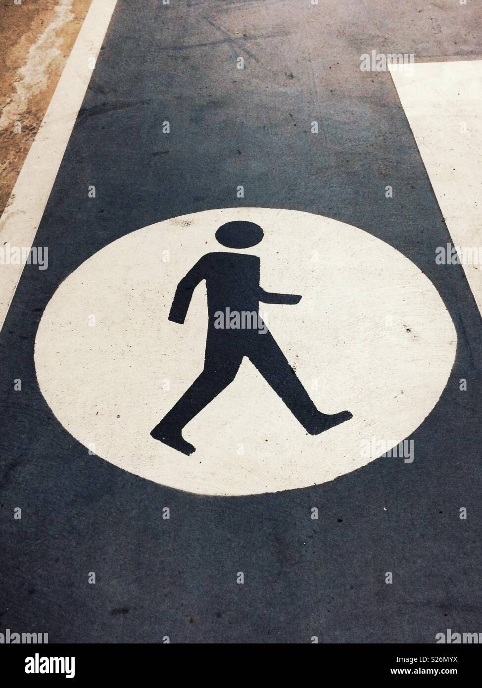 Sign of person walking on the concrete floor of a car park Stock Photo ...