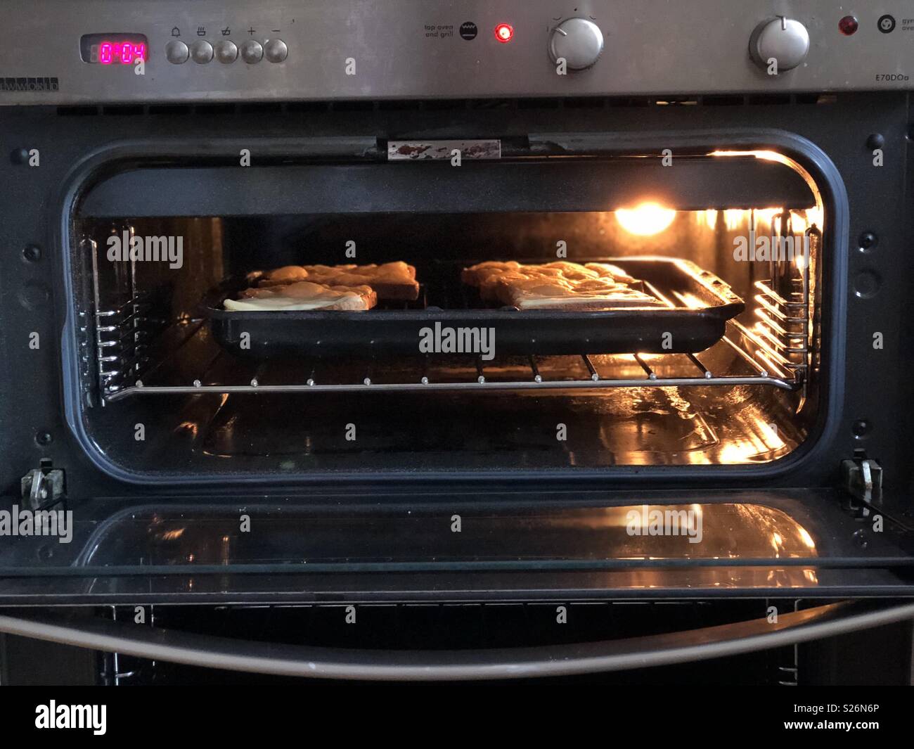 Cheese and toast being cooked under the grill Stock Photo - Alamy
