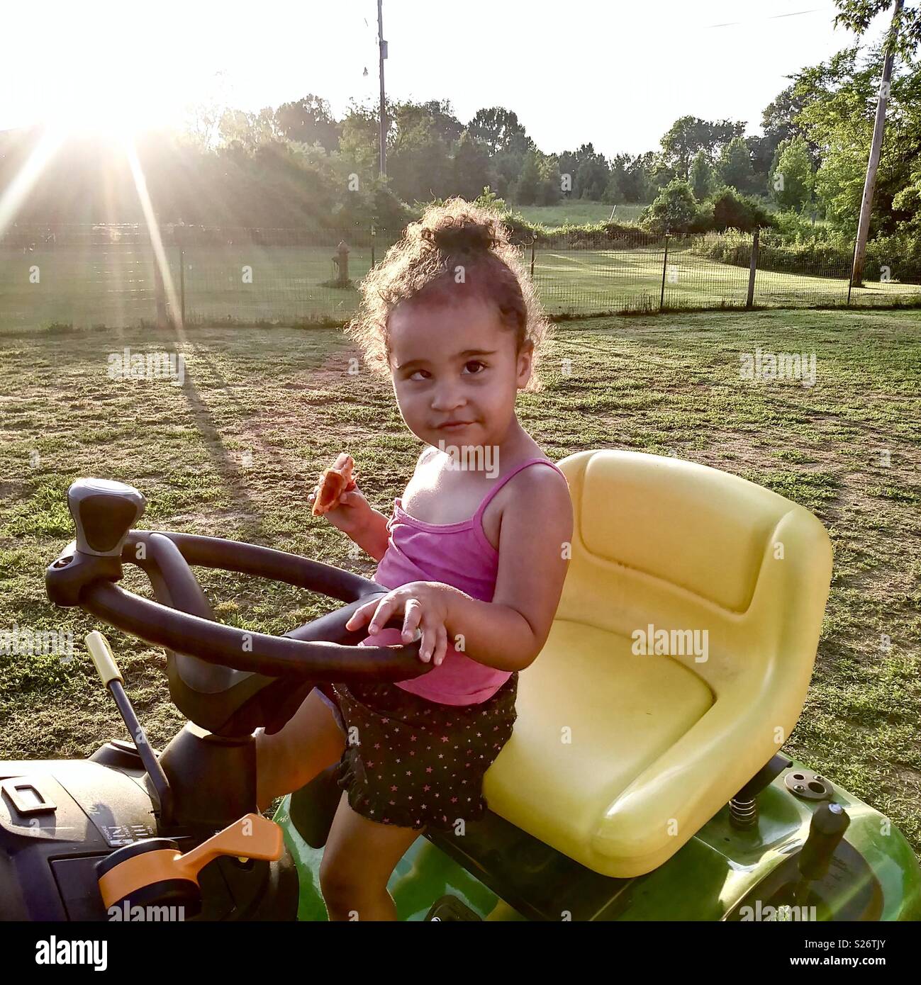 Cute baby sitting on a riding lawn mower Stock Photo - Alamy