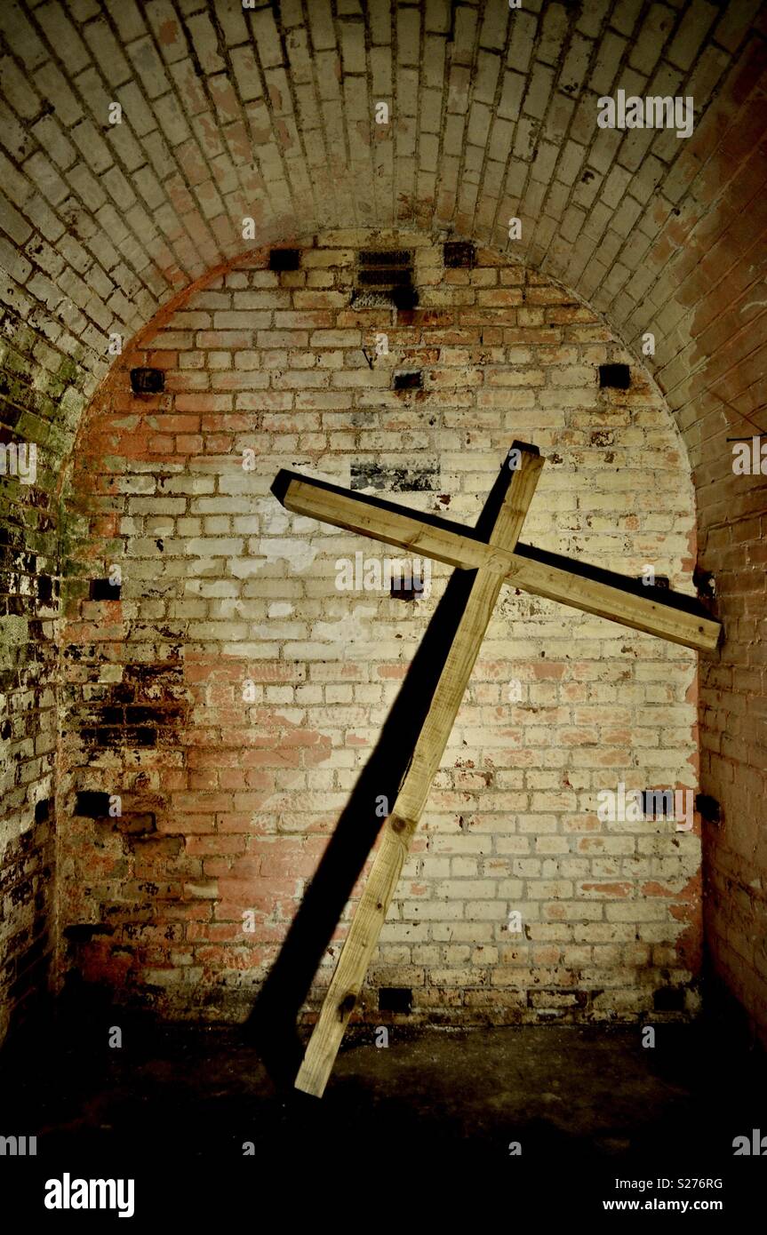 Still Life - Crucifix leaning on a brick wall Stock Photo - Alamy