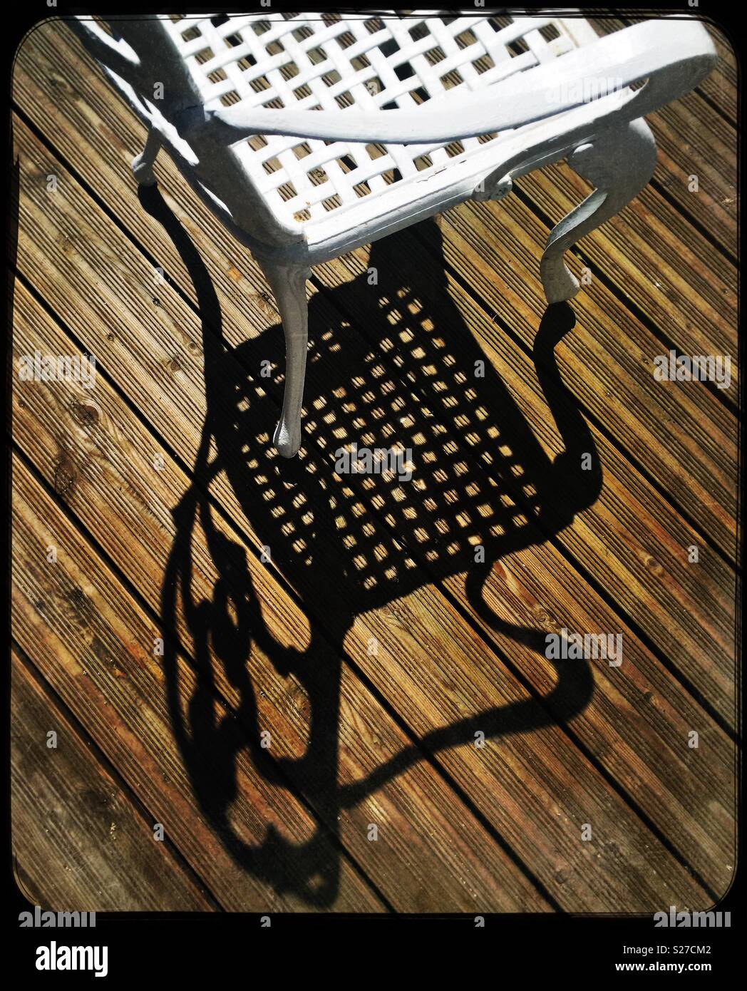 Shadow chair on decking Stock Photo - Alamy
