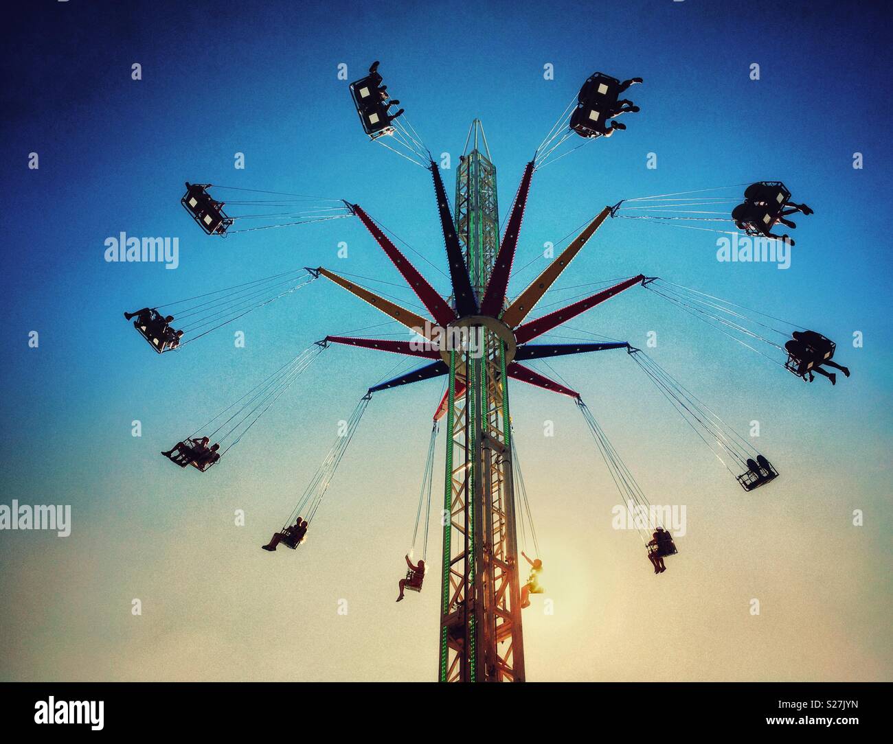 Aerial fairground ride silhouetted against the sun Stock Photo - Alamy