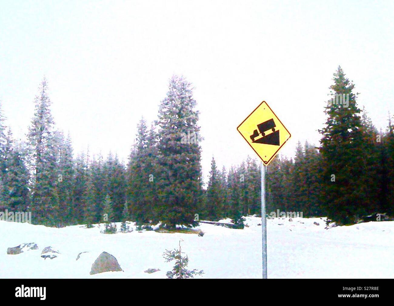Downhill traffic sign in a winter pine forest Stock Photo - Alamy