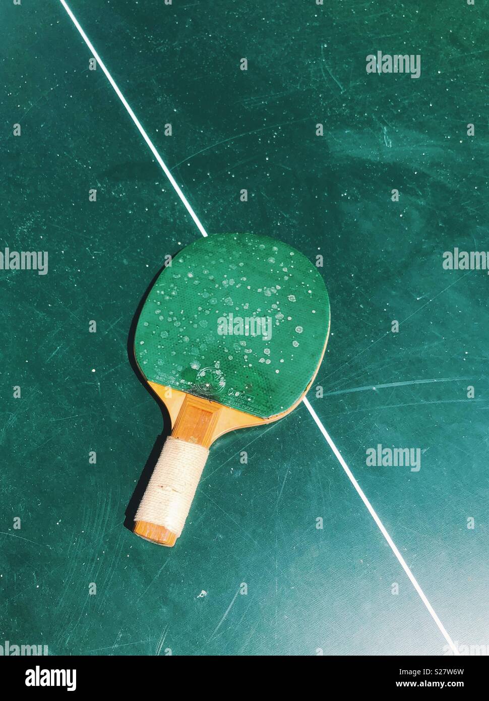 A vintage ping pong or table tennis bat on an old green table top Stock ...