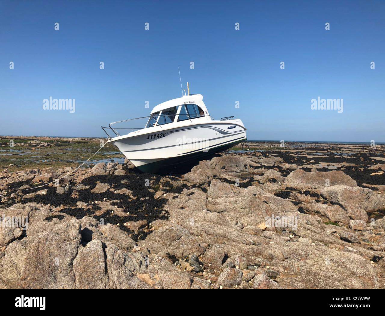 Boat on rocks Stock Photo - Alamy