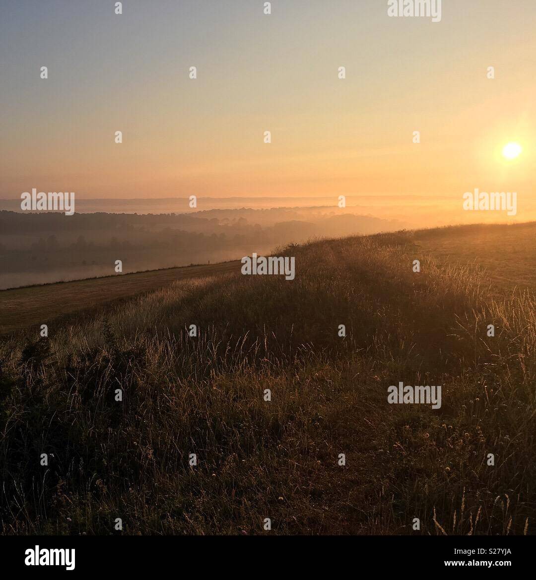 Dawn on Chiselbury Iron Age hill fort, looking out over Fovant Down and ...