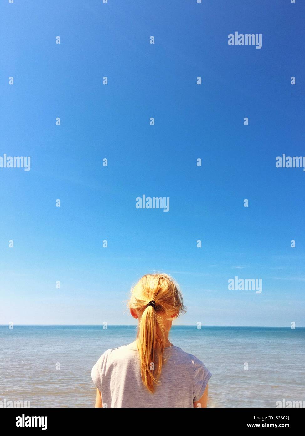 Young girl looking out to sea Stock Photo - Alamy