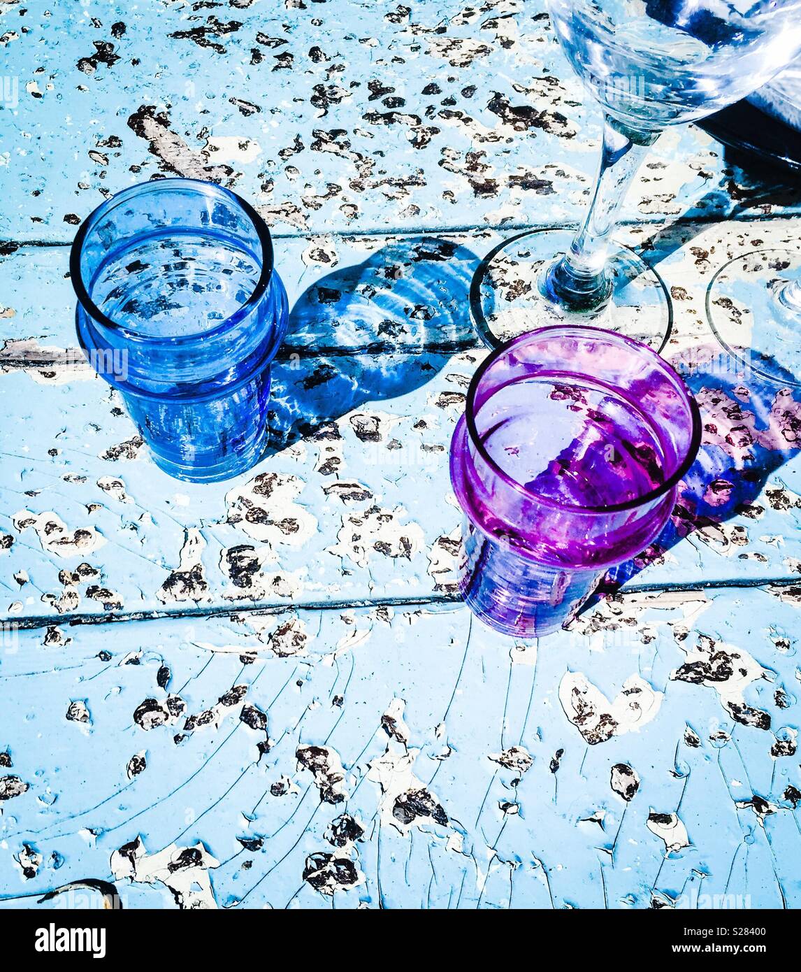 Coloured glasses on a chipped paint table Stock Photo - Alamy
