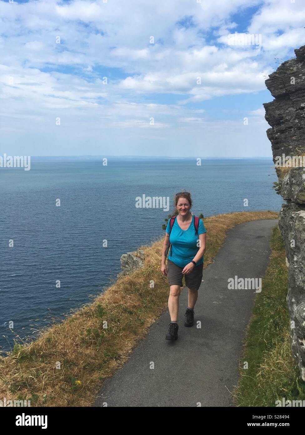 Woman walking on a cliff top path in North Devon Stock Photo - Alamy