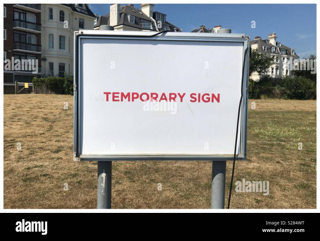 A sign of a temporary sign on a green space Stock Photo - Alamy
