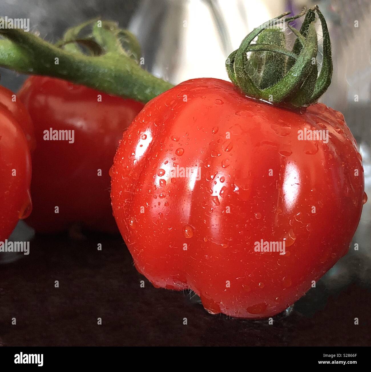 Washed red vine tomatoes draining on a granite chopping block Stock ...