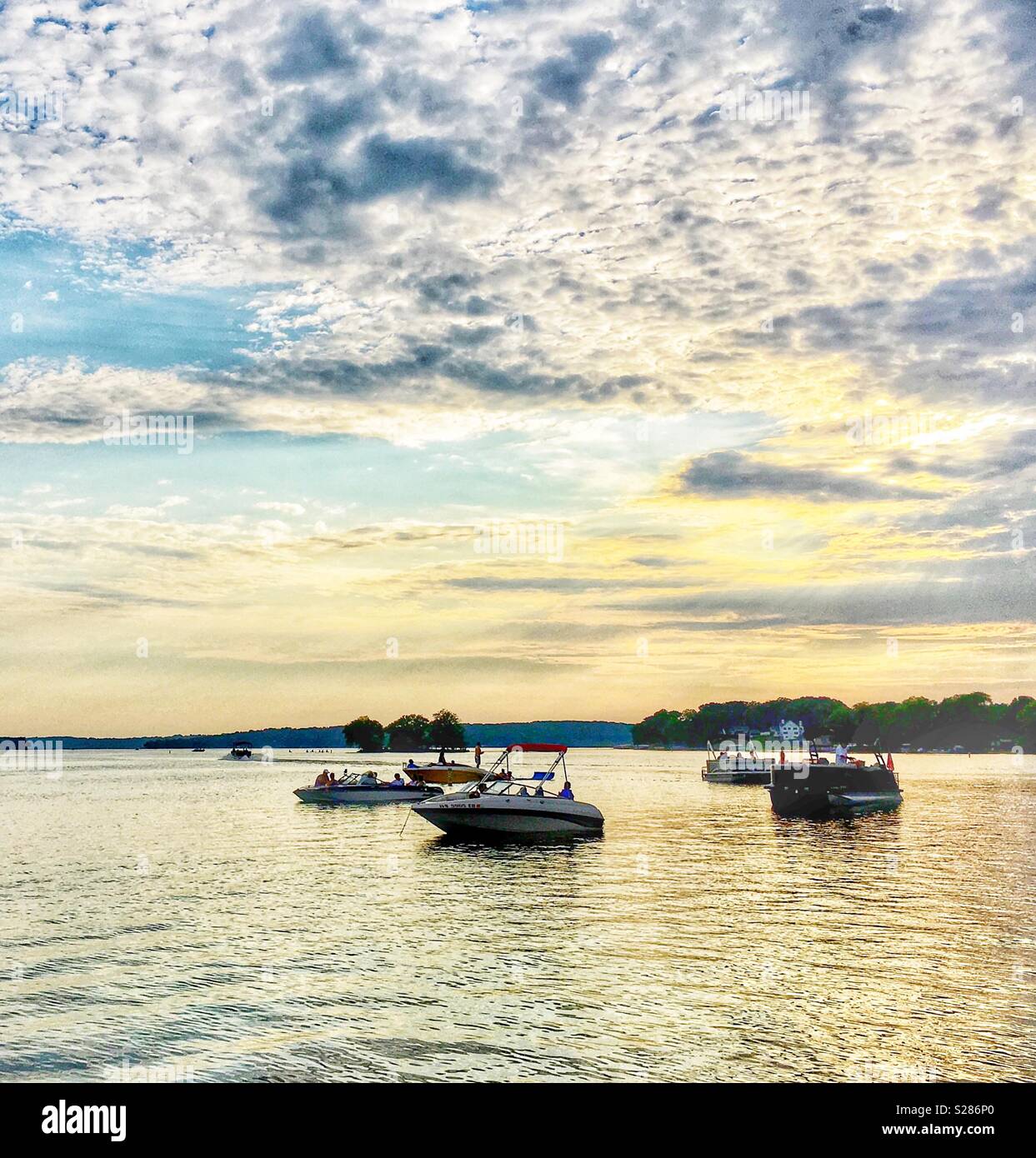 Boats cruising on Pewaukee Lake at sunset Stock Photo - Alamy