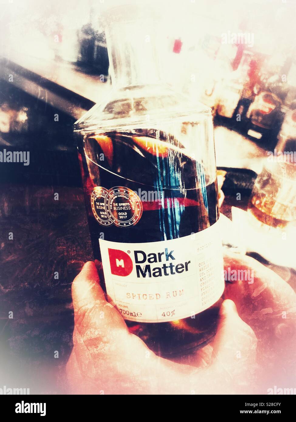 Holding a bottle of rum Stock Photo - Alamy