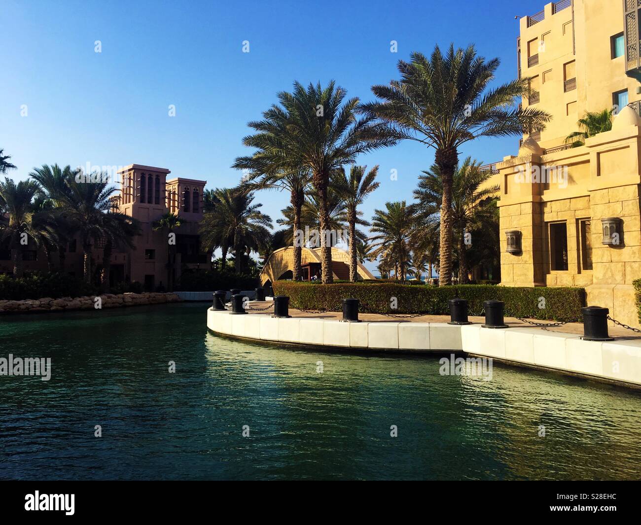 Old Arabic buildings and trees overlooking a river with palm trees ...