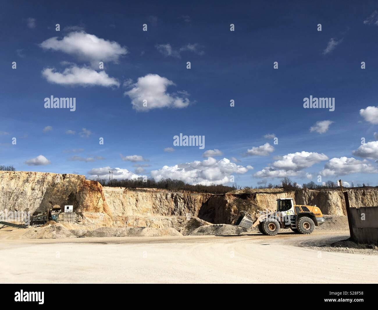 Dredge in a quarry under blue sky with white clouds Stock Photo - Alamy