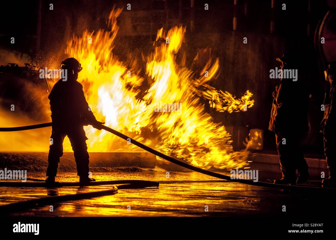 Firefighters fighting a fire Stock Photo - Alamy