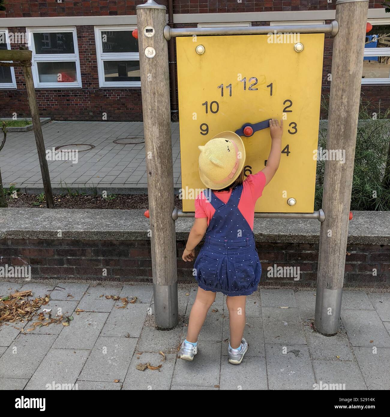 Child learning the time in a school playground Stock Photo - Alamy