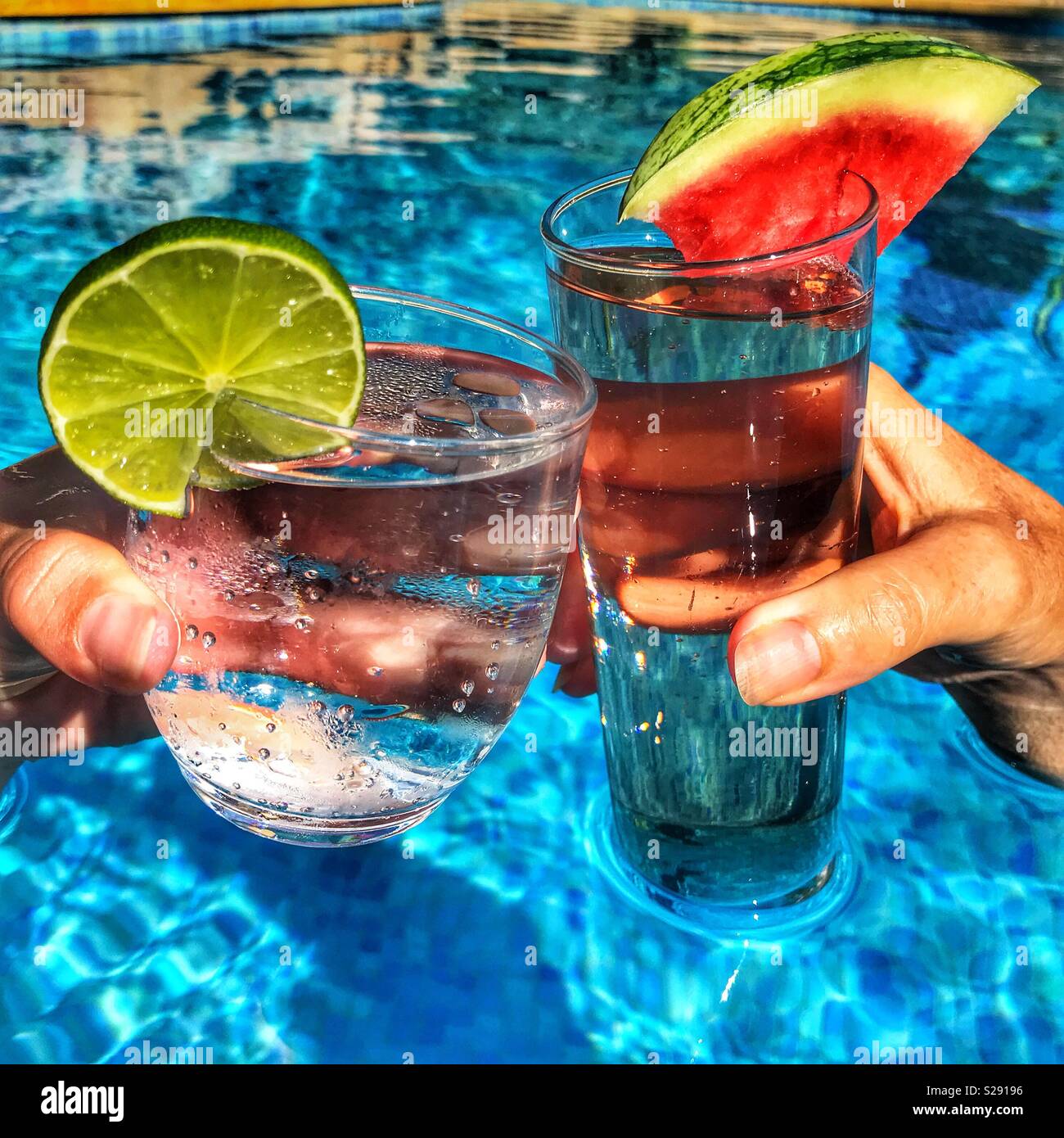 Cheers! Celebratory toast with cocktails in a swimming pool Stock Photo ...