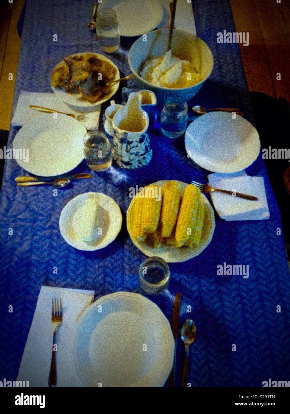 Simple summer supper- evening meal set at blue themed table consisting ...