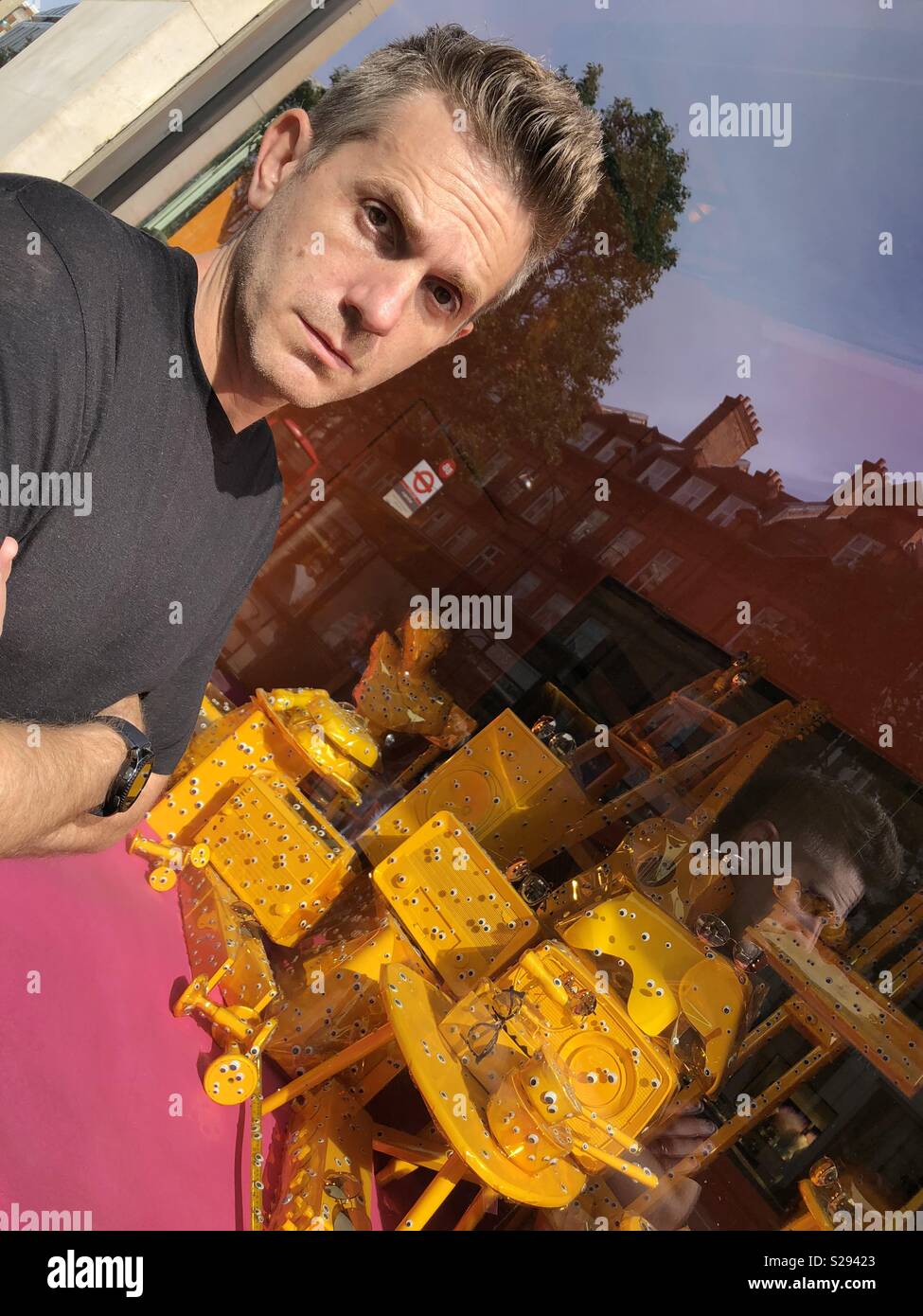Man looking fed up in front of window display Stock Photo - Alamy