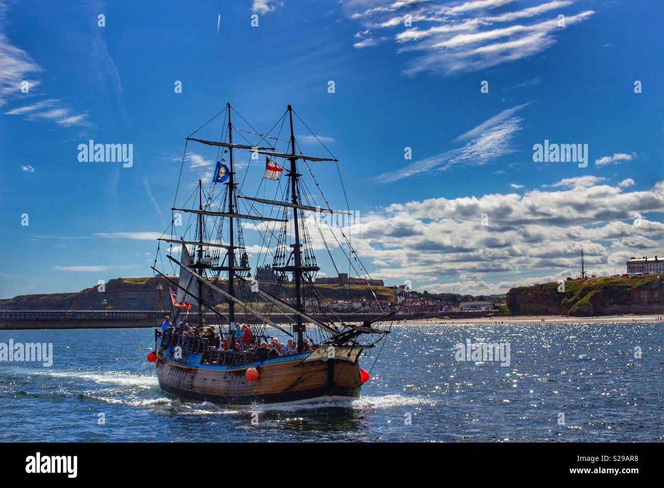 Sailing ship on the sea beside the coast Stock Photo - Alamy