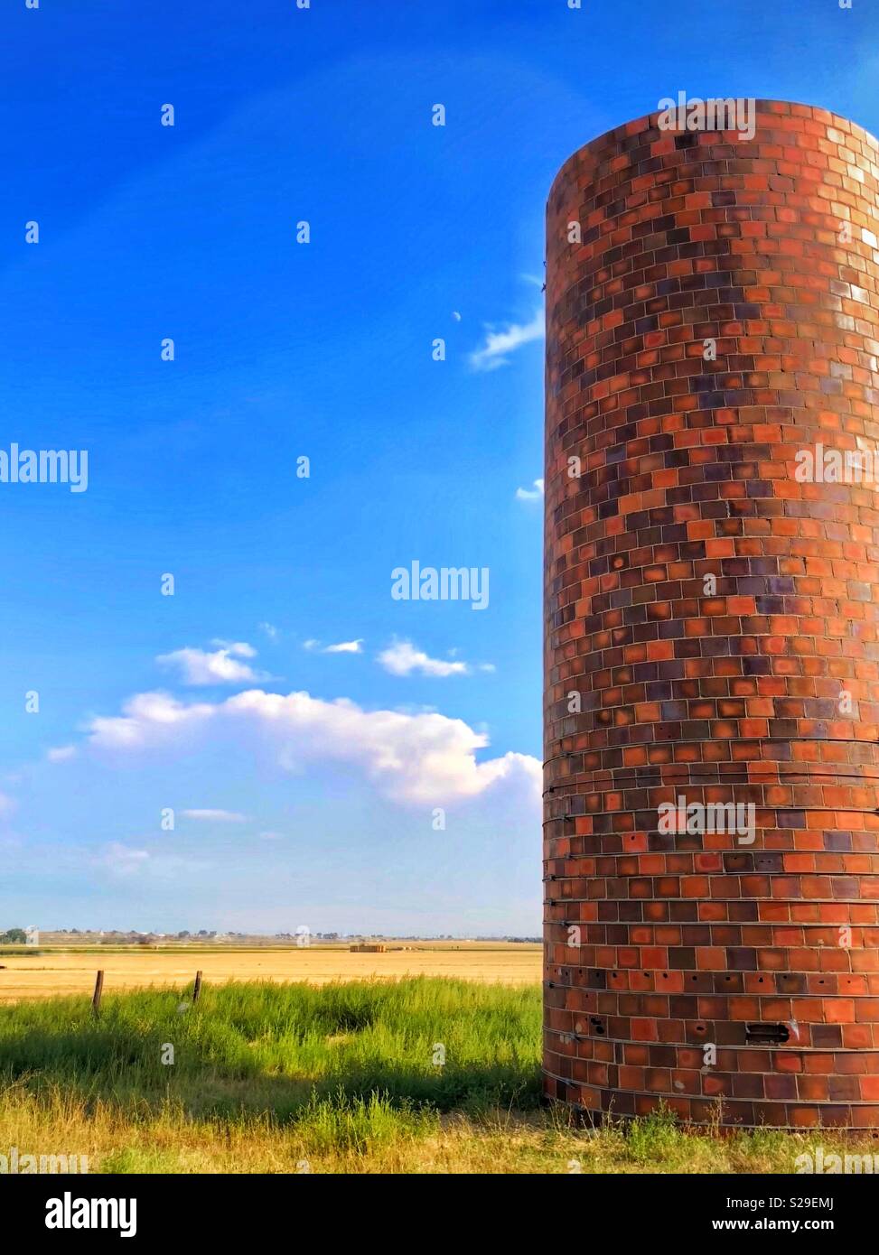 Brick grain silo with wheat fields in background, Colorado sky’s Stock ...