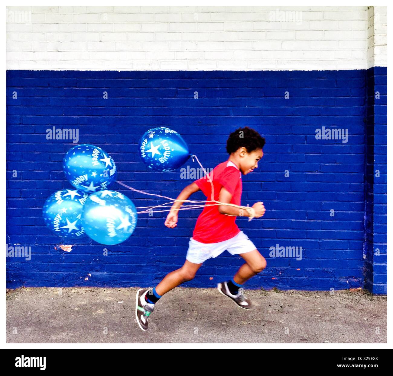 A little boy running with balloons Stock Photo - Alamy