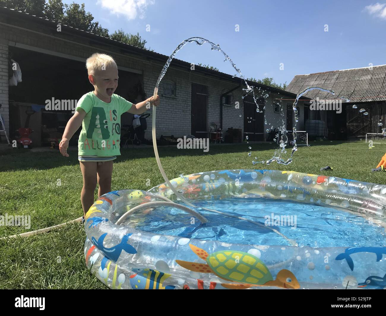 Baby boy playing with Waterhouse Stock Photo - Alamy